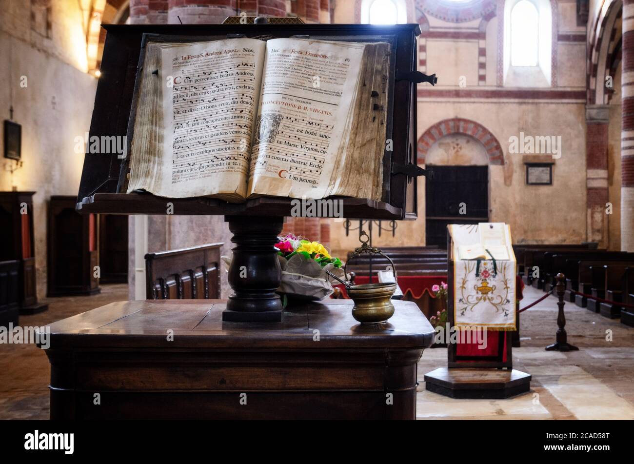 Ancient latin manuscript with religious chants and music sheets over a ...