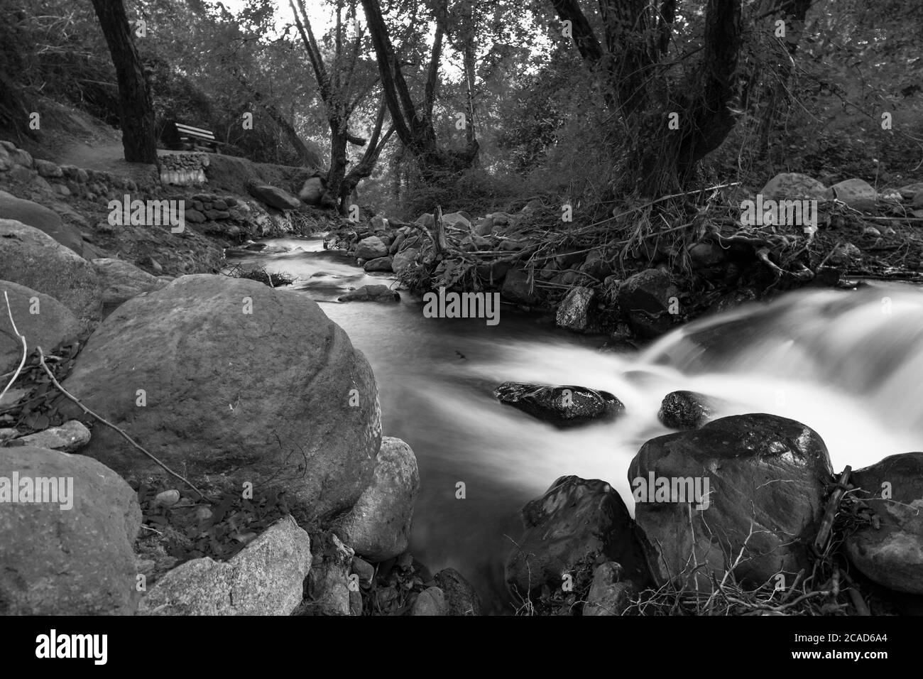 Pure water stream with smooth flow over rocky mountain terrain in the ...