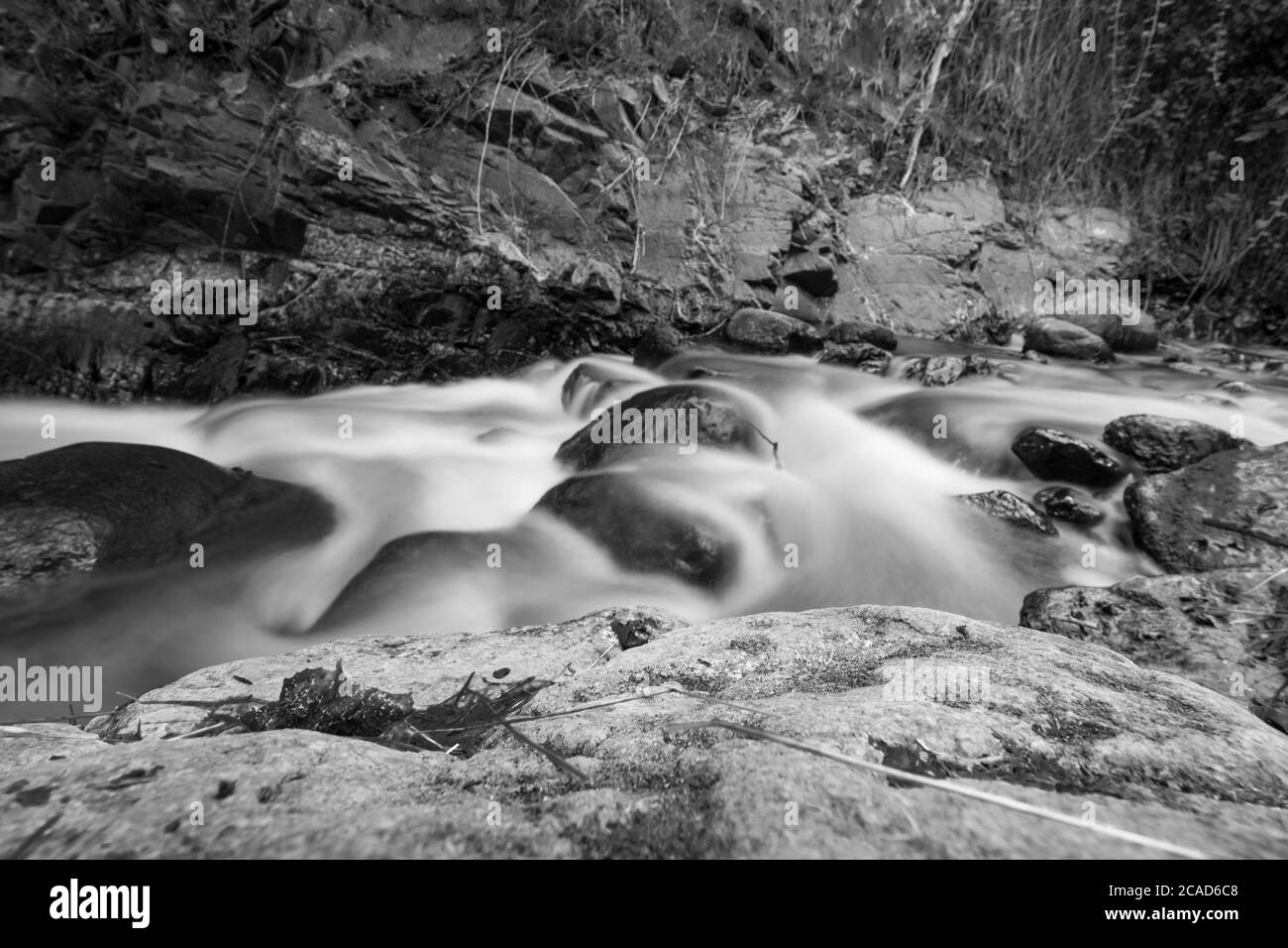Pure water stream with smooth flow over rocky mountain terrain in the ...