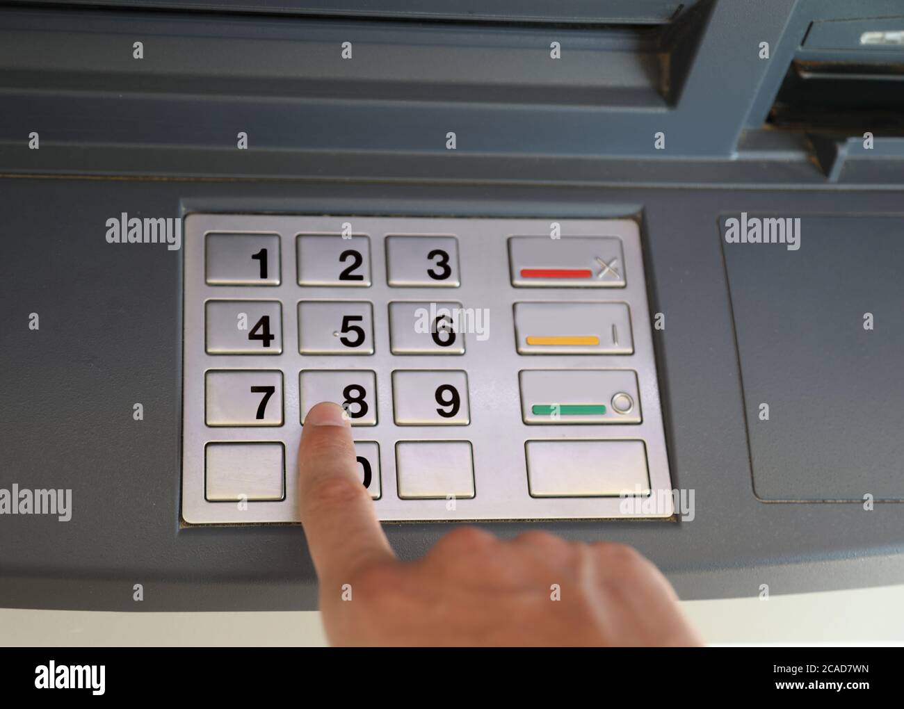 hand of the person typing the secret code into the ATM machine keyboard ...