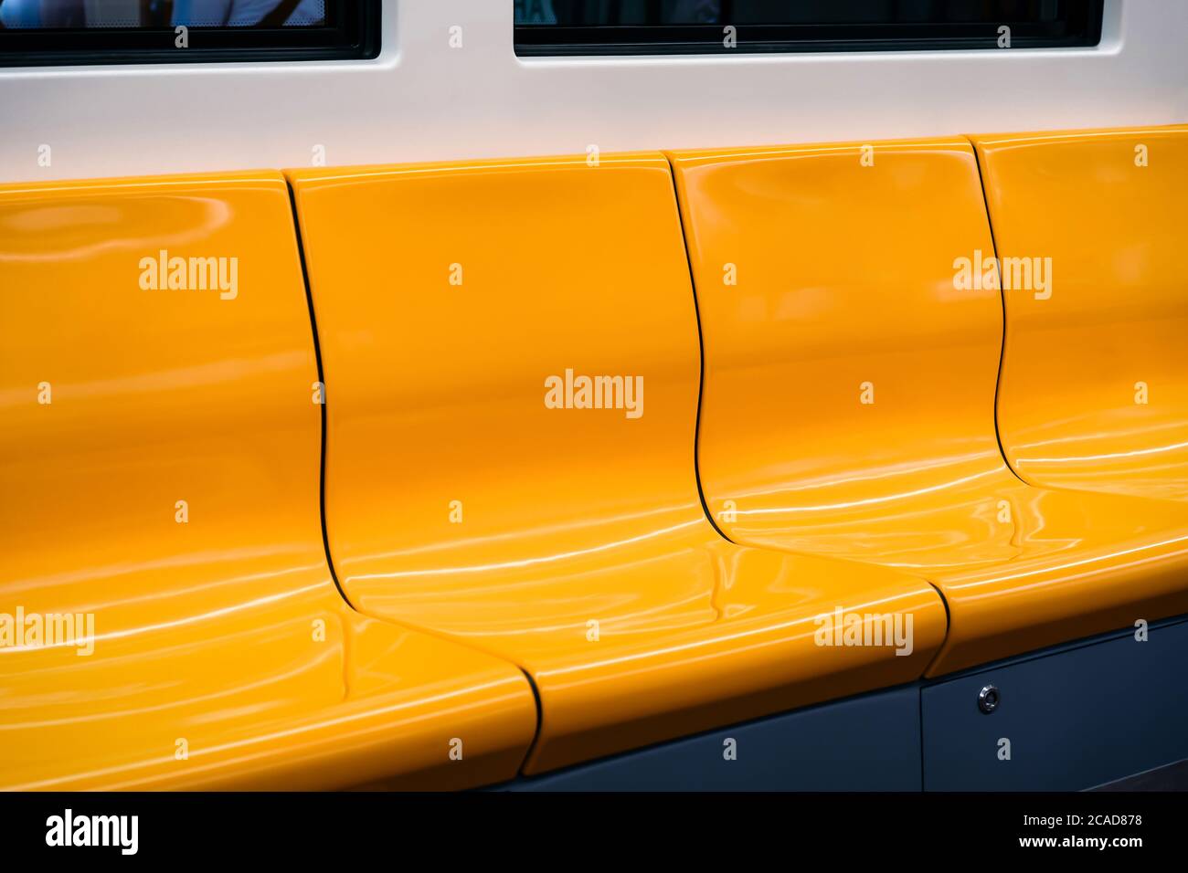 Close up to the yellow chairs that are set on the row inside the train ...