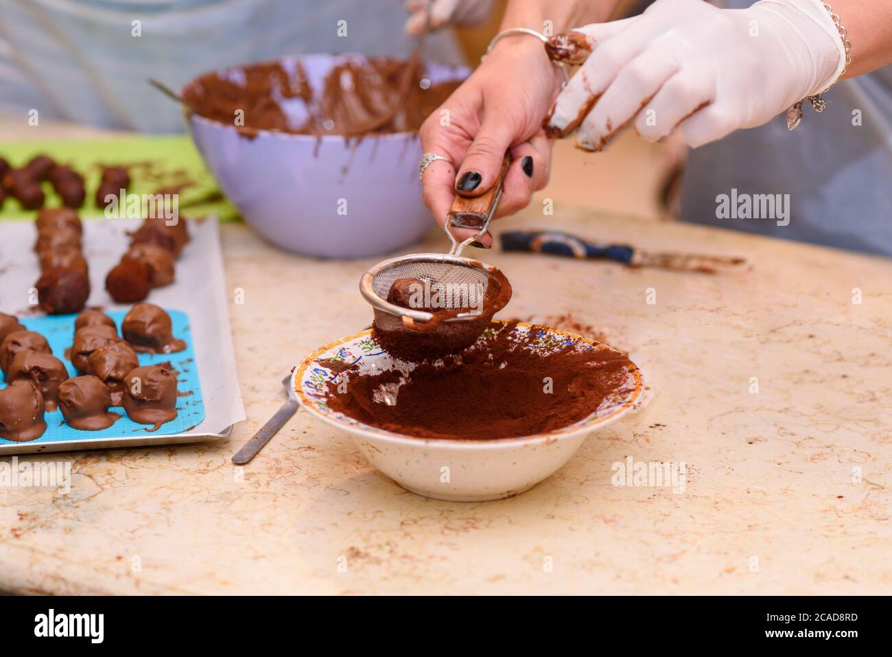 Cooking concept. Young woman making chocolate candies. Close up hands ...
