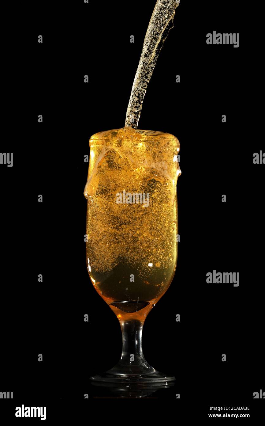 Beer falling into a glass and forming a splash on a black background ...