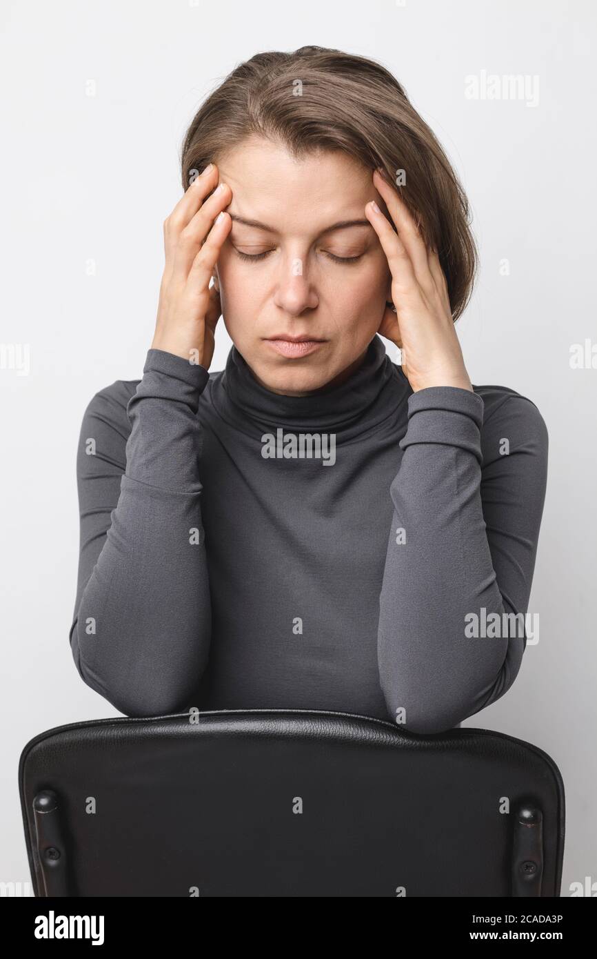 The woman is holding her head. Headache. Fatigue Stock Photo - Alamy