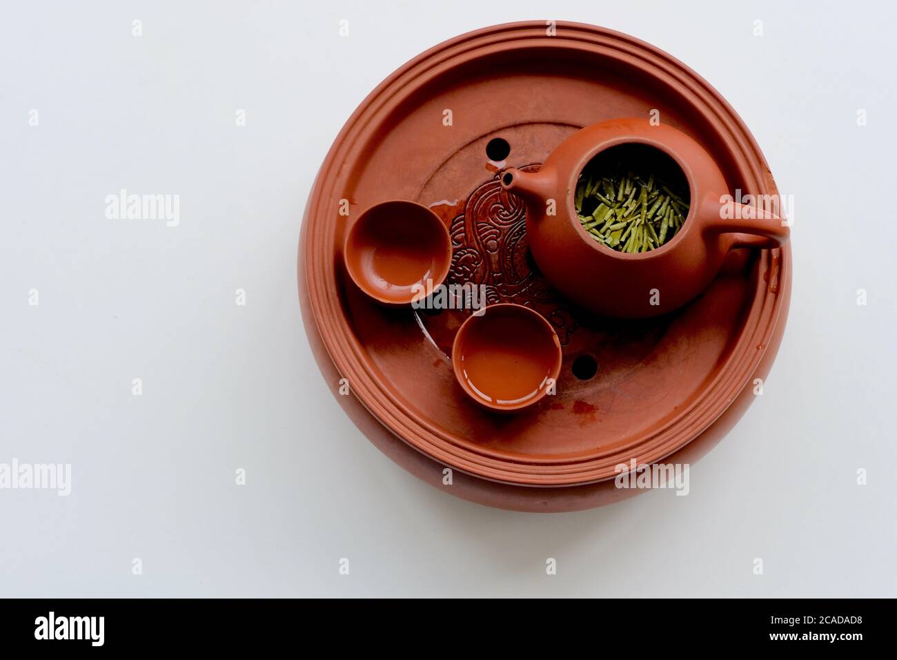 Top view of red brown ceramic sand fired teapot and teacups on white ...