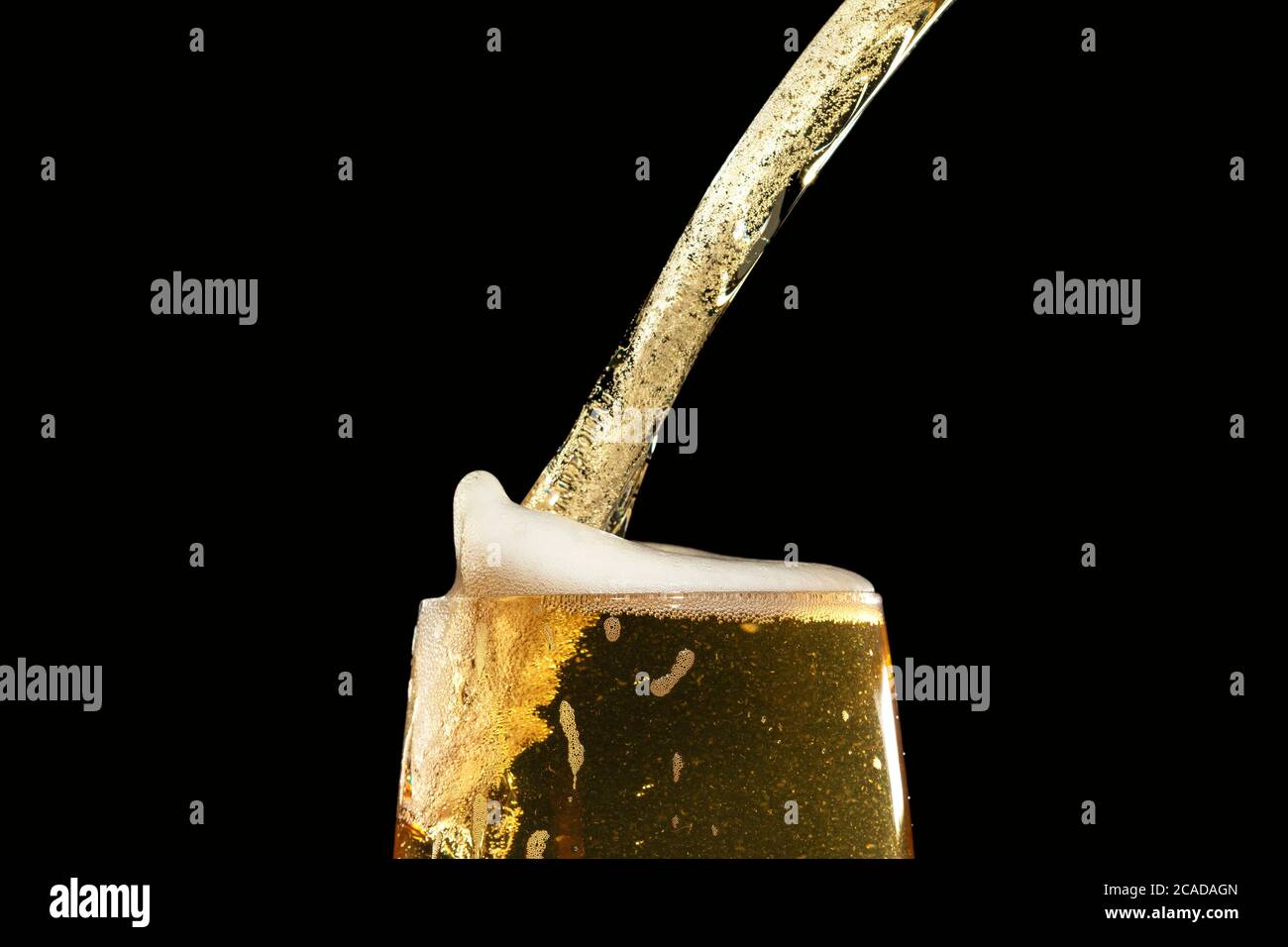 Beer falling into a glass and forming a splash on a black background ...