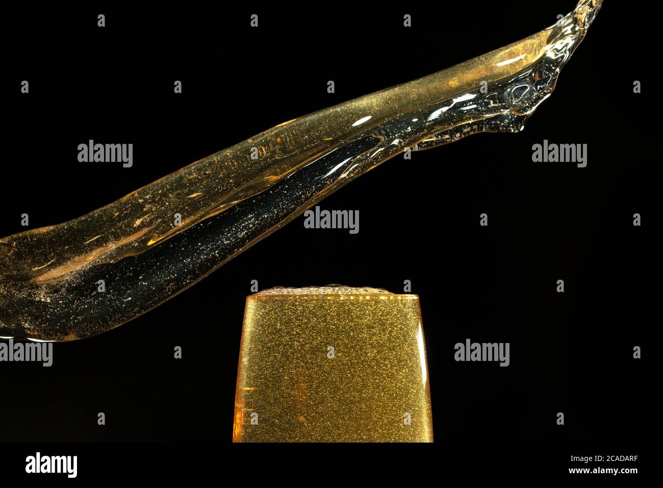 Beer falling into a glass and forming a splash on a black background ...