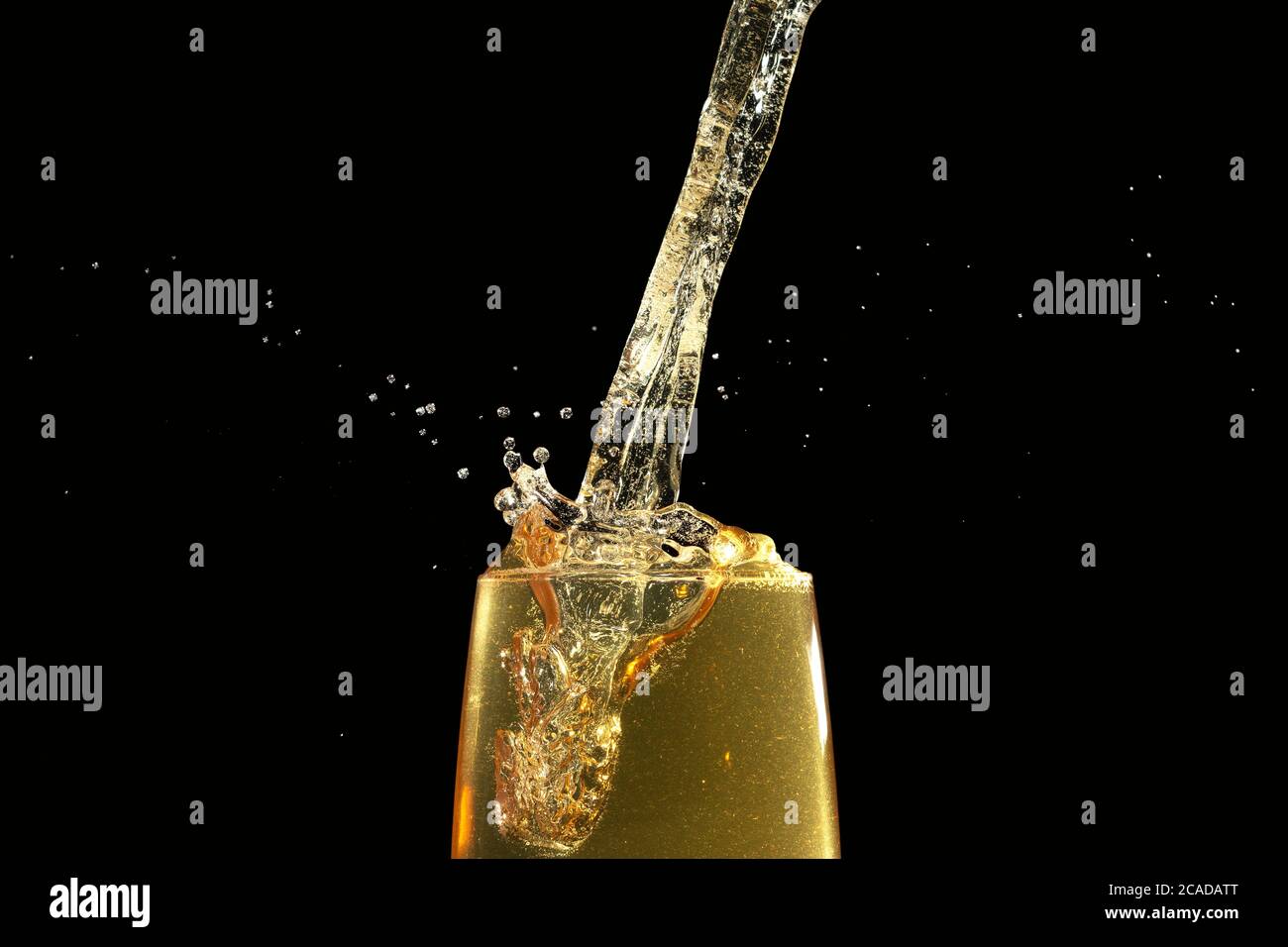 Beer falling into a glass and forming a splash on a black background ...
