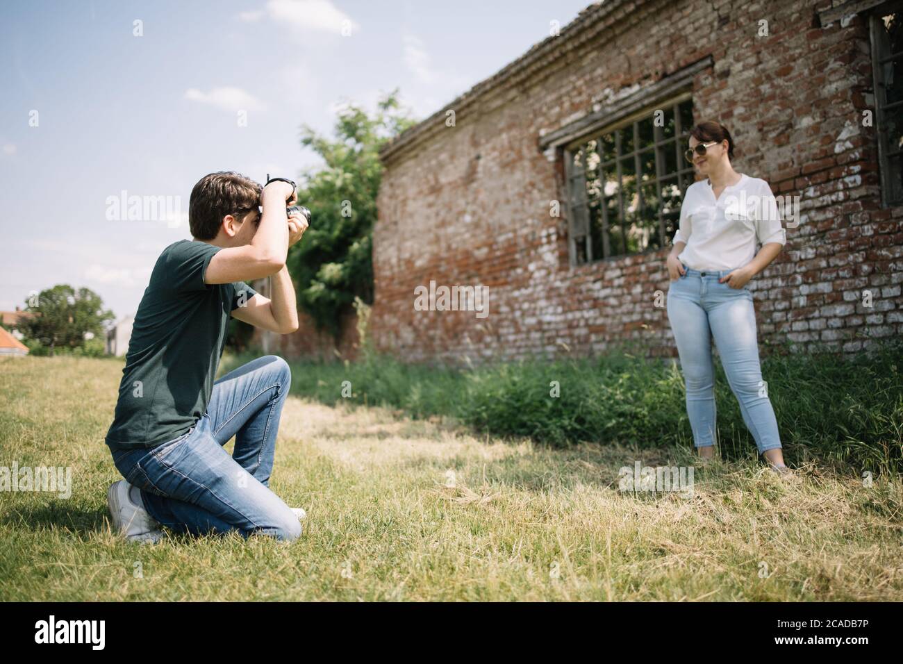 Male photographer photographing a female model in village Stock Photo ...