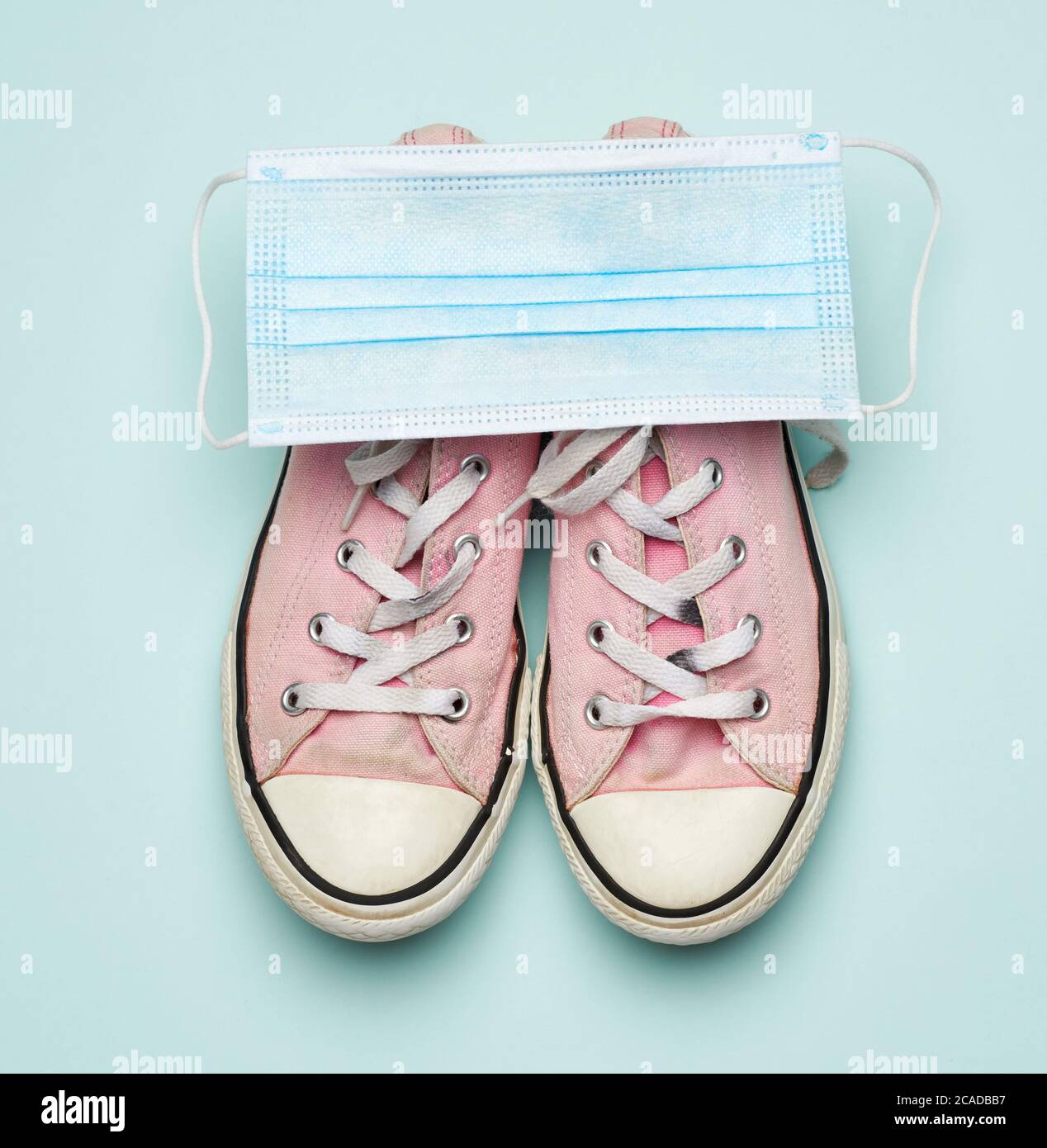 mask and pink sneakers on a blue background, safe walks during a viral ...