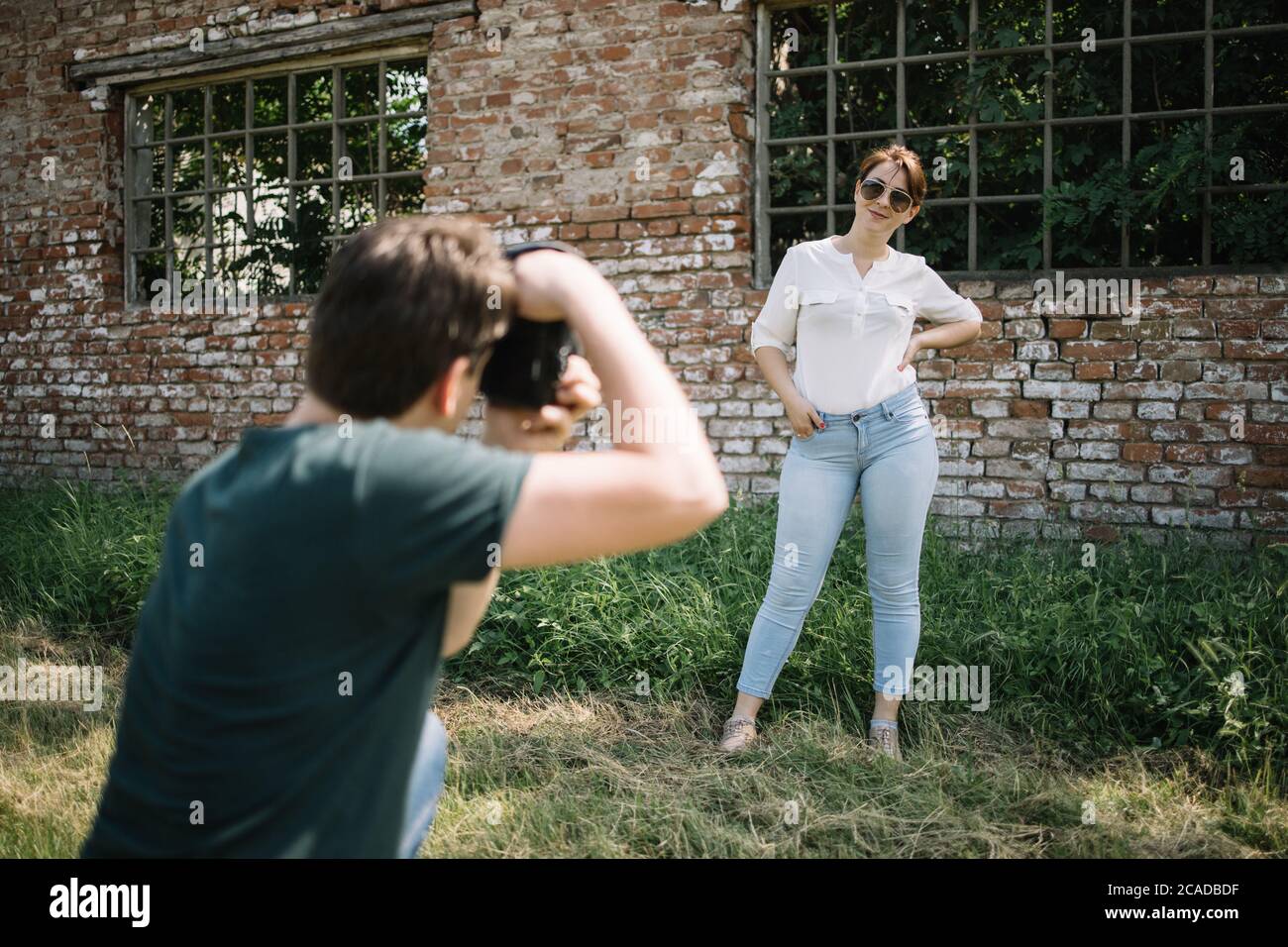 Photographer taking photos of model using camera Stock Photo - Alamy