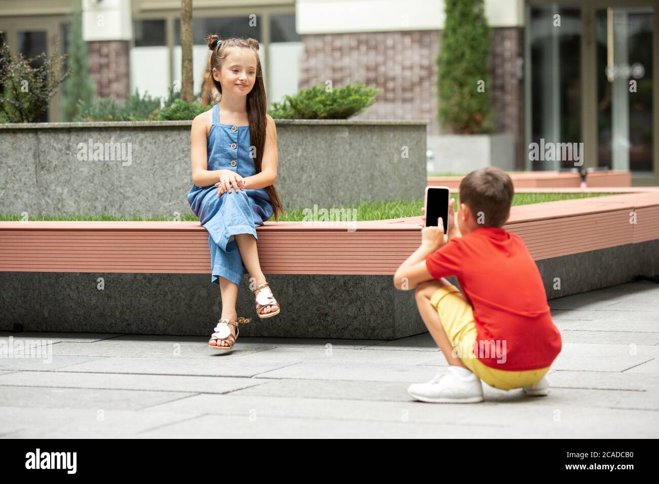 Two smiling kids, boy and girl taking photo together in town, city in ...