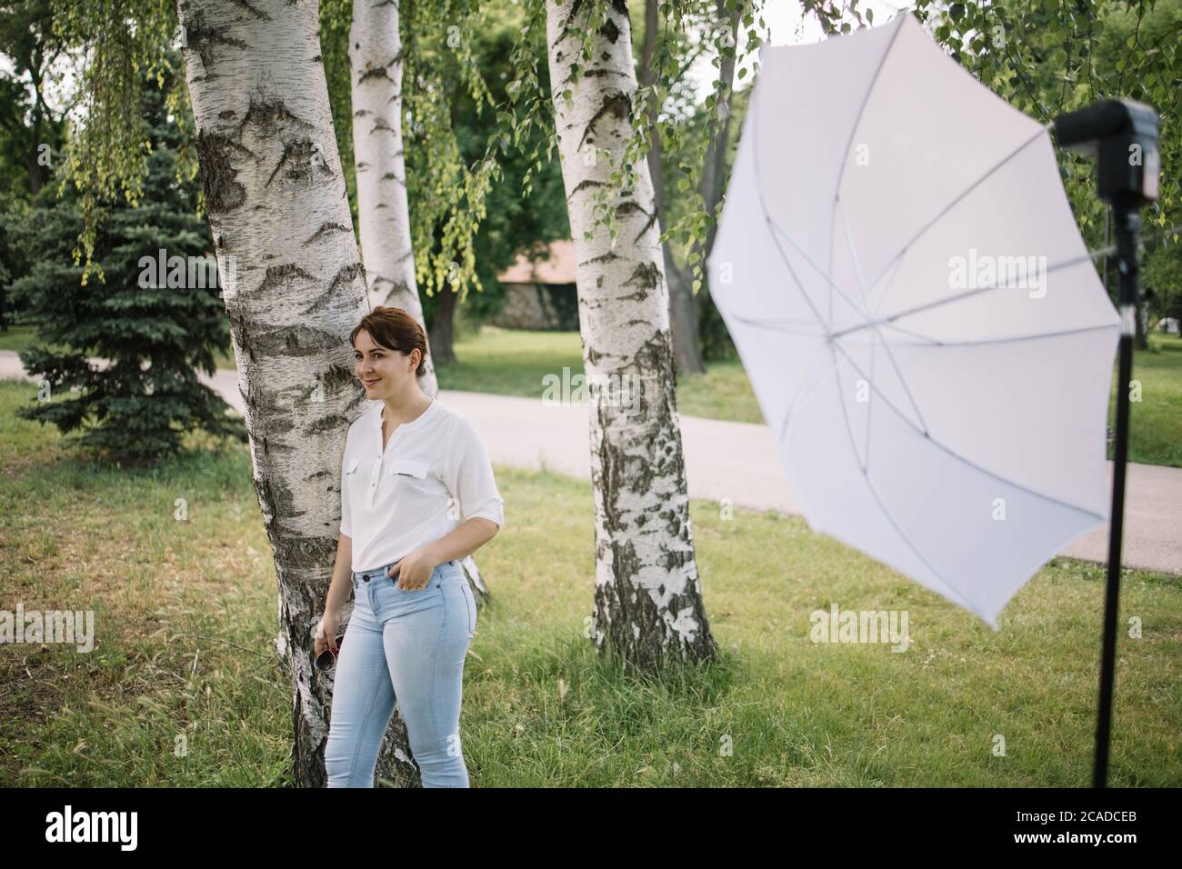 Female model posing next to birch tree and umbrella on stand Stock ...