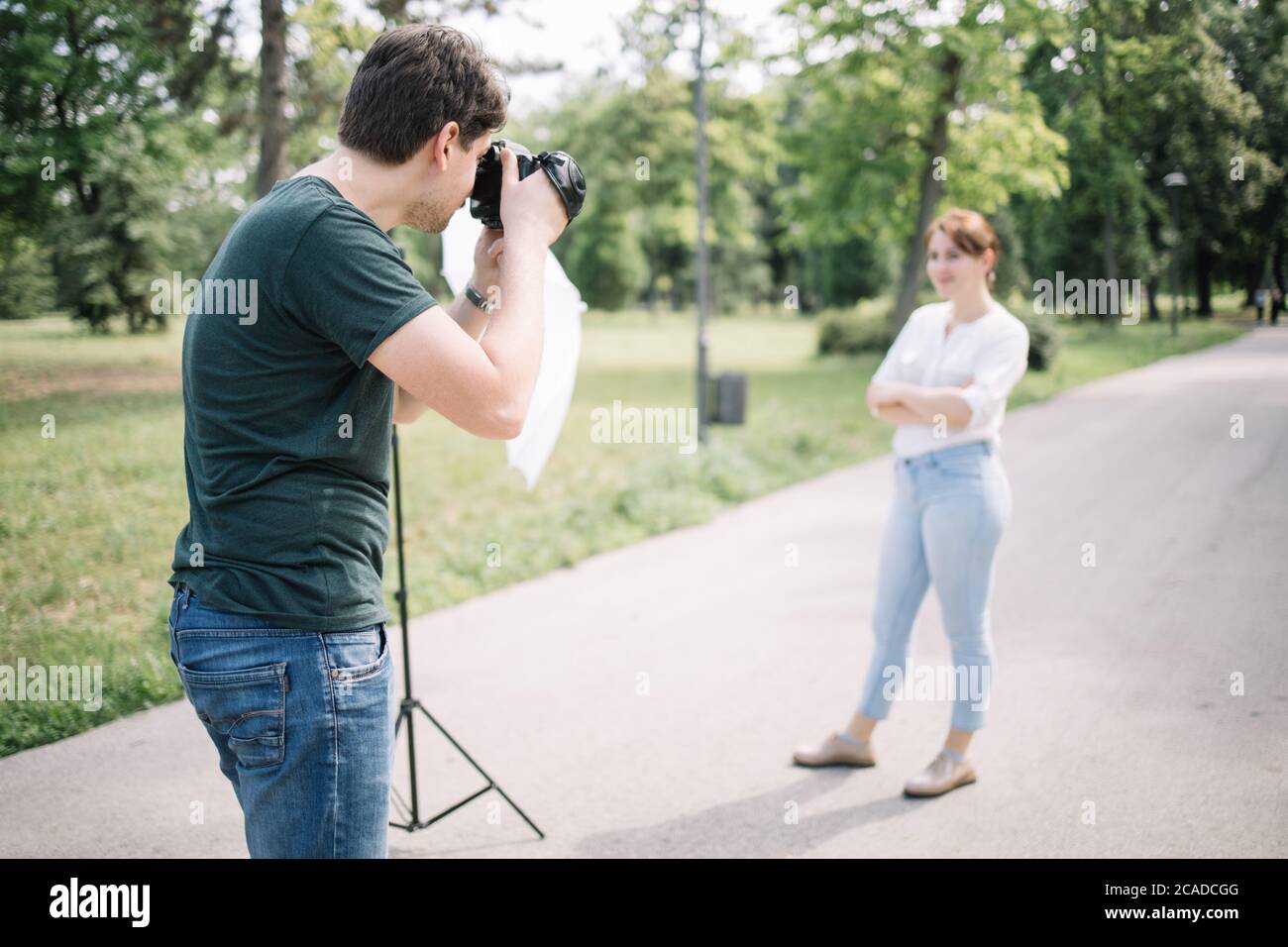 Back view of man taking pictures of blurred woman Stock Photo - Alamy