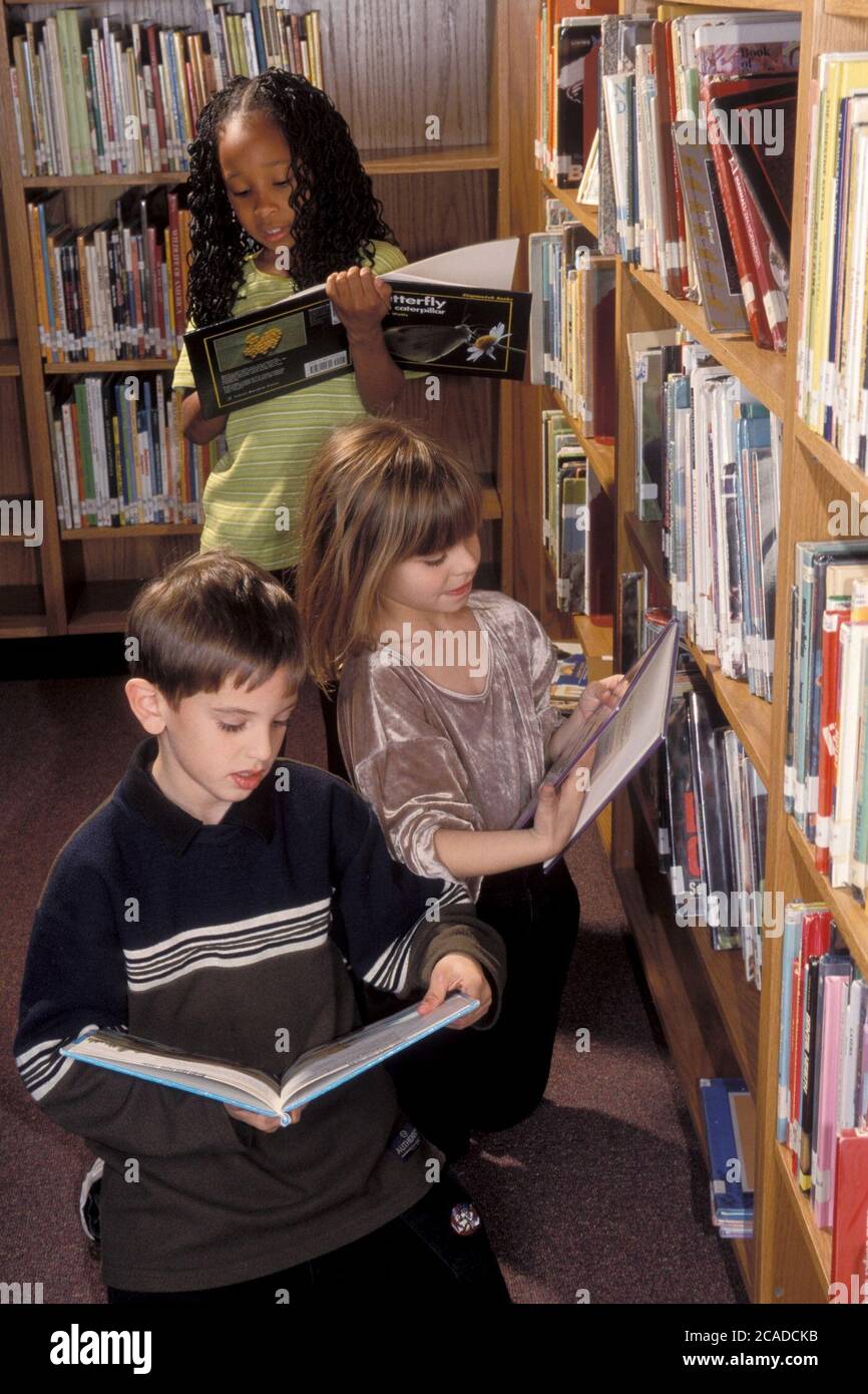 First graders in school library looking at and and reading books. ©Bob ...
