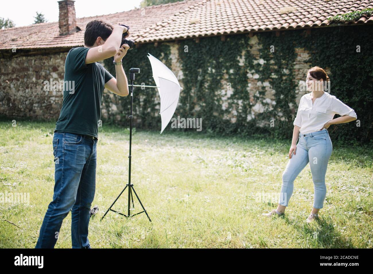 Side view of photographer photographing professional model Stock Photo ...