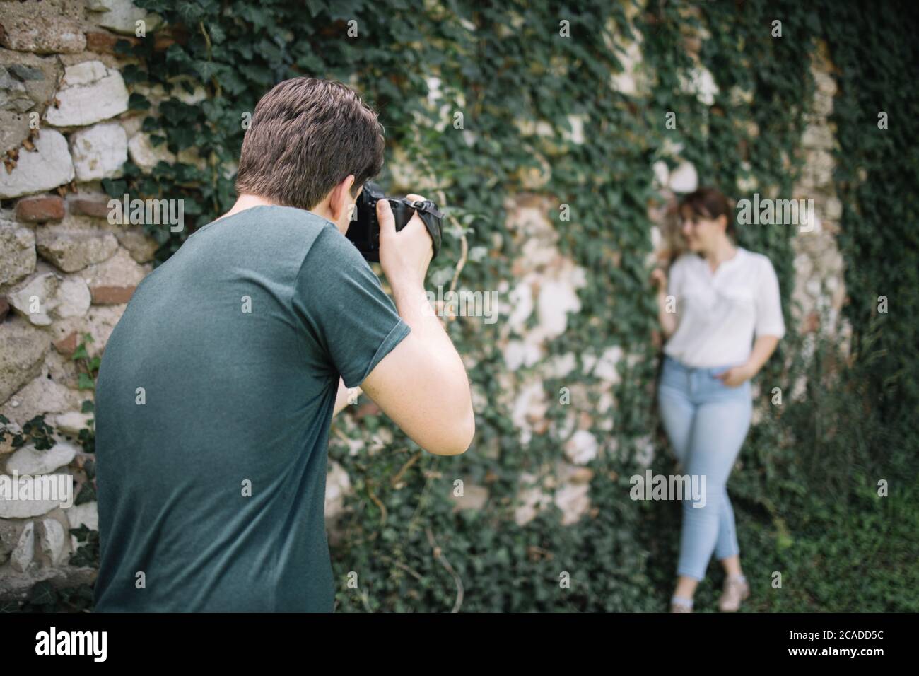 Back view of photographer taking photos of woman outdoor Stock Photo ...