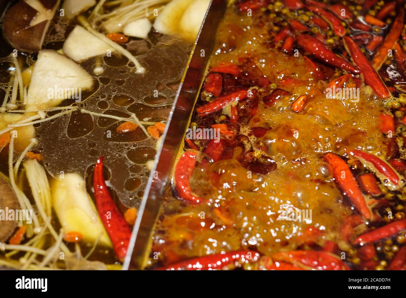 close up traditional Chinese double-flavor hot pot. Red peppers and ...