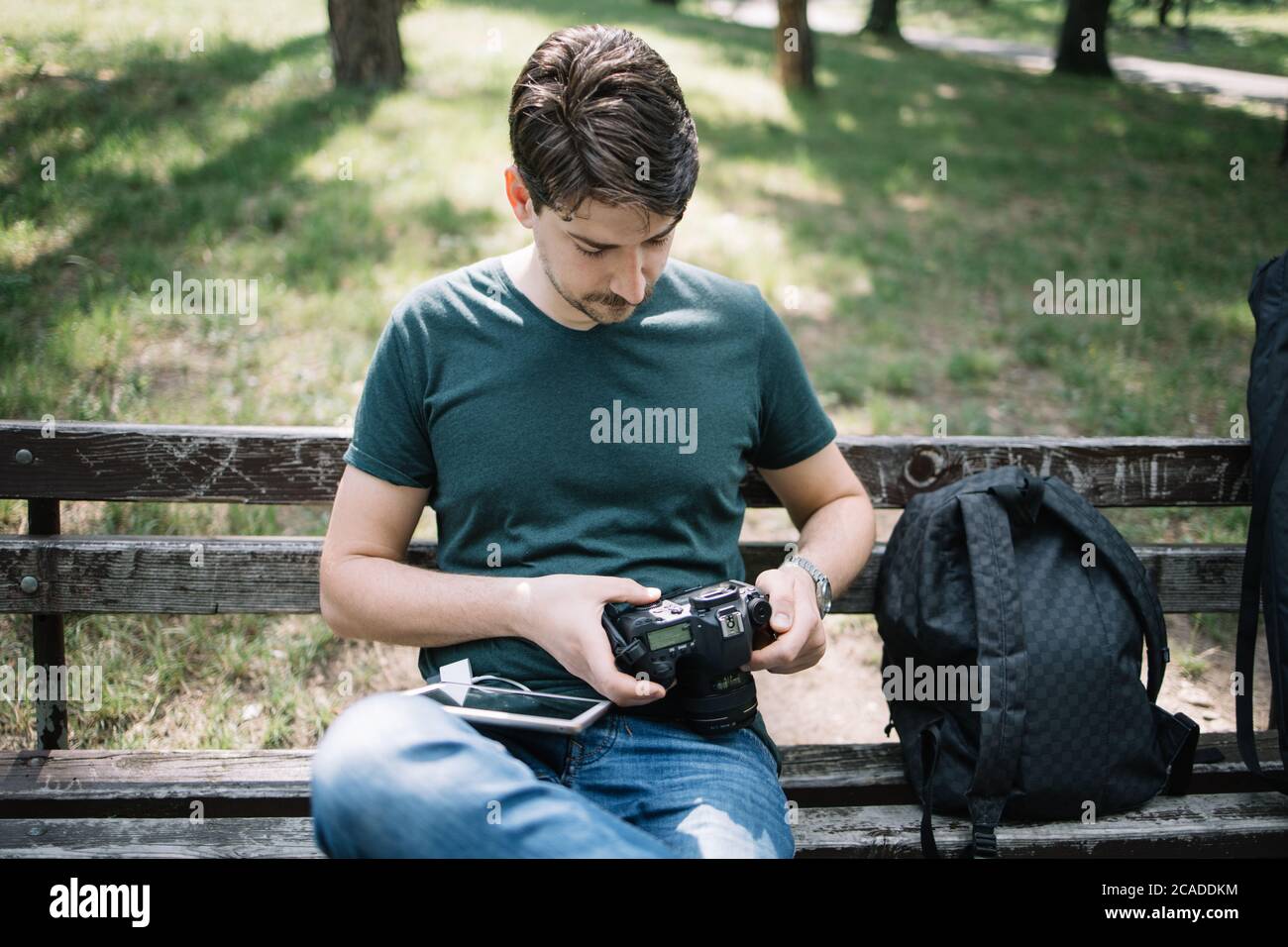 Photographer checking photoshoot photos while sitting on bench Stock ...