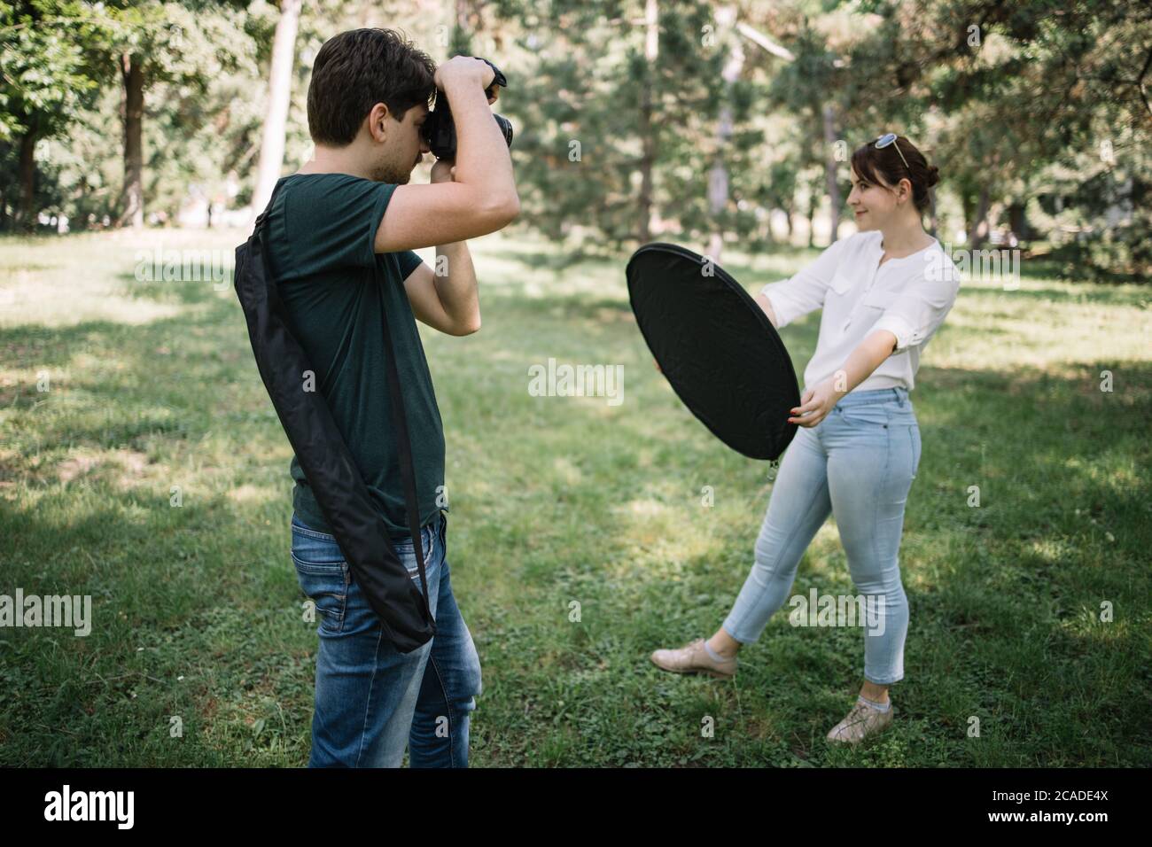Side view of photographer taking pictures of woman Stock Photo - Alamy