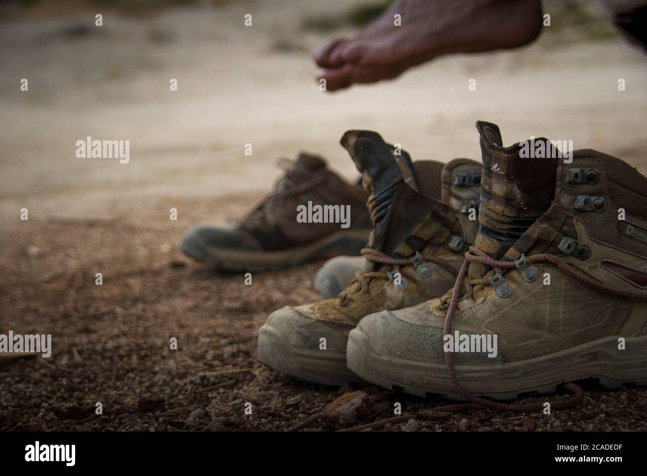 Dirty trekking boots with dust at the end of a long hike, laying on the ...