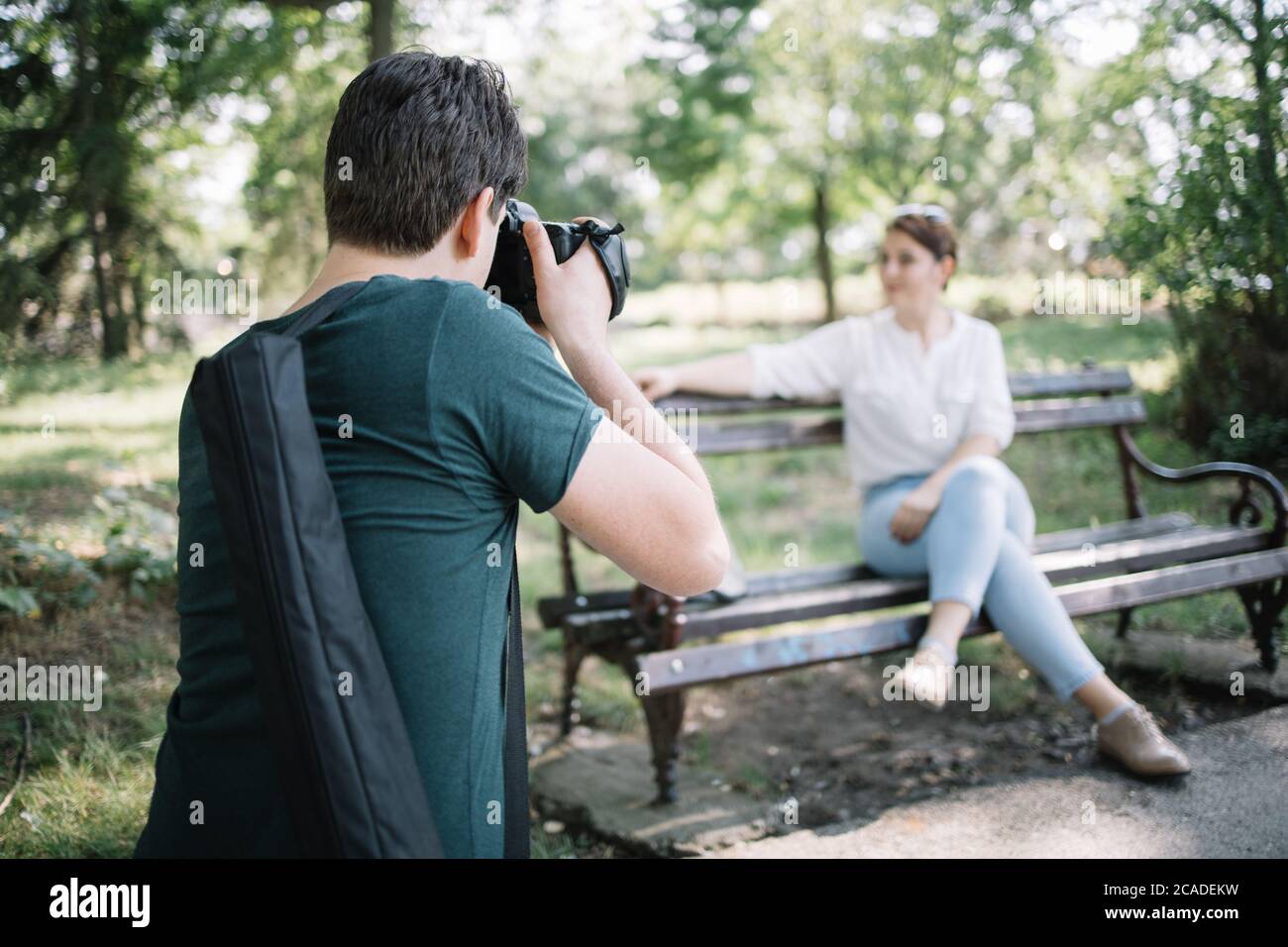 Back view of man taking photo session of blurred model outdoor Stock ...