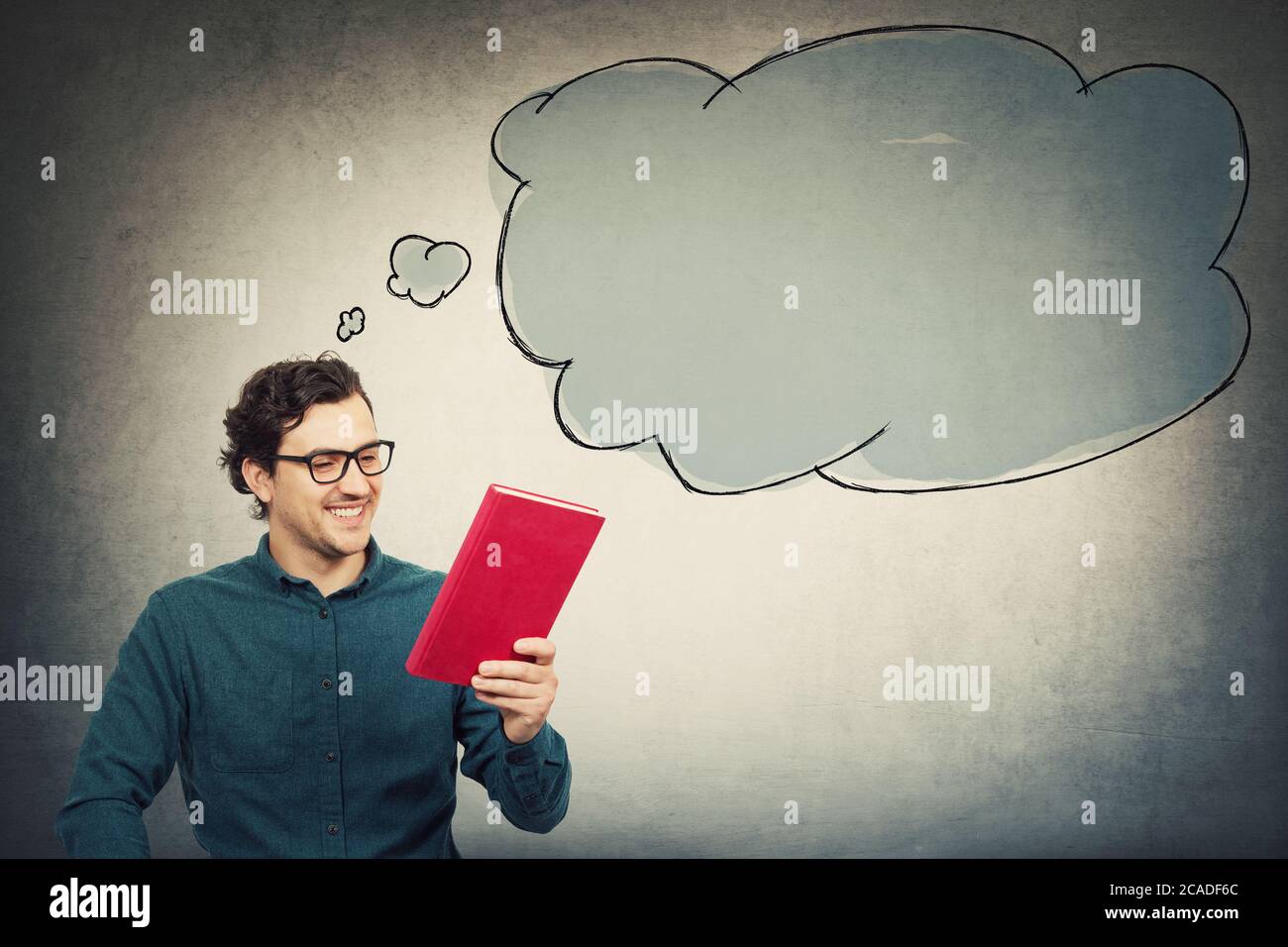 Happy young man, student guy, holding an interesting red book, reading ...