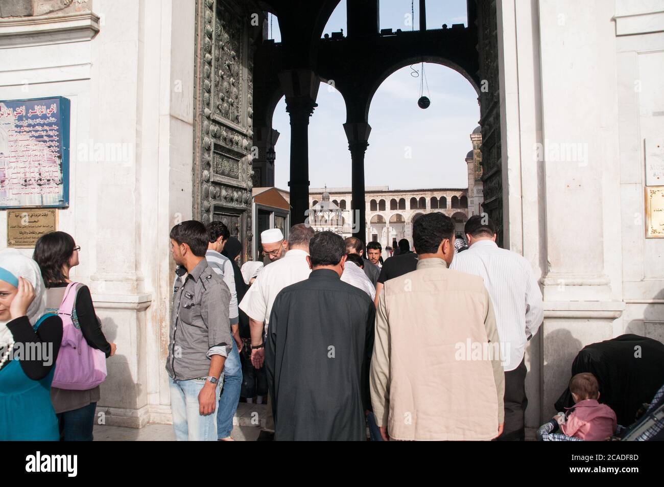 Syrian Muslim worshippers entering the open-air courtyard of the ...