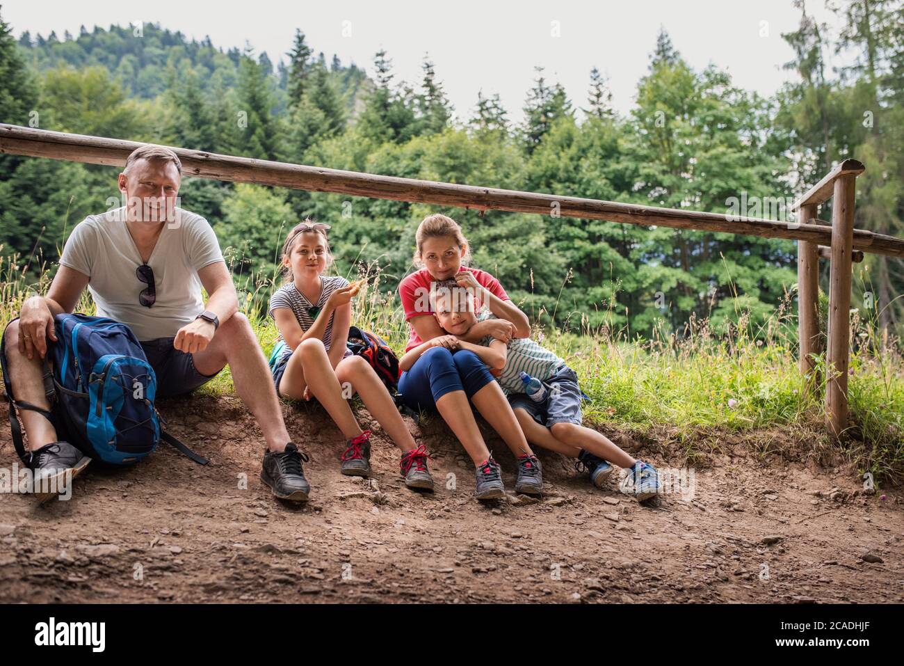 Portrait of smiling parents and their two cute children sitting on a ...