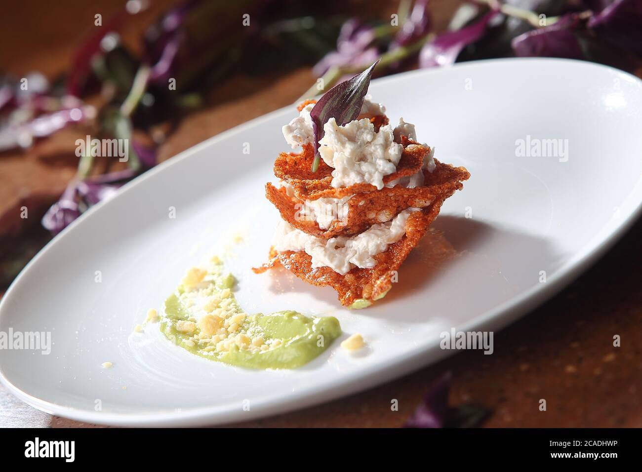 Closeup shot of chicharron enchilado with goat cheese and avocado sauce ...