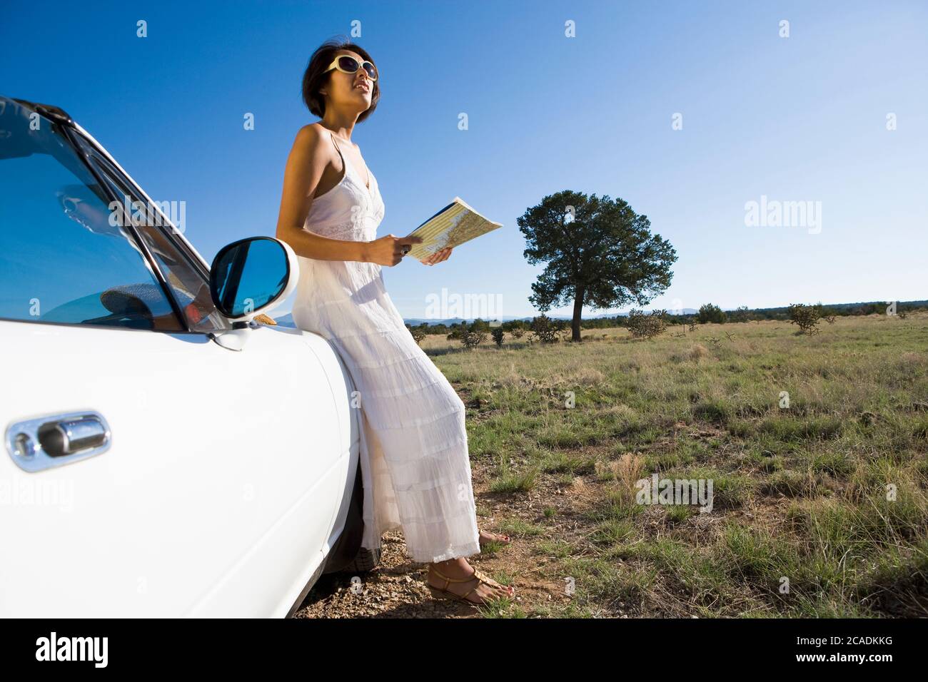 Native American woman in sun dress driving a white convertible sports ...