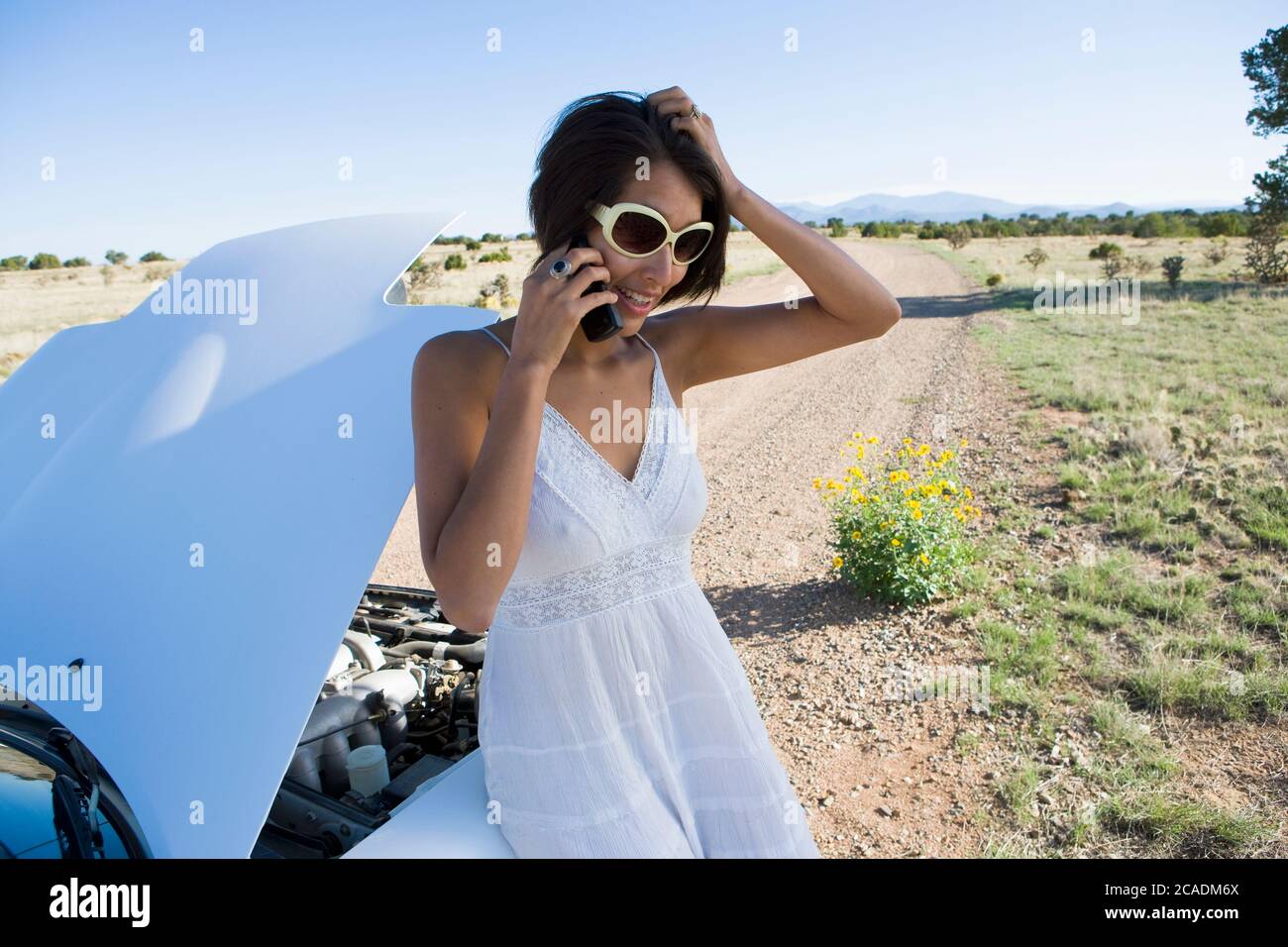 Native American woman in sun dress driving a white convertible sports ...