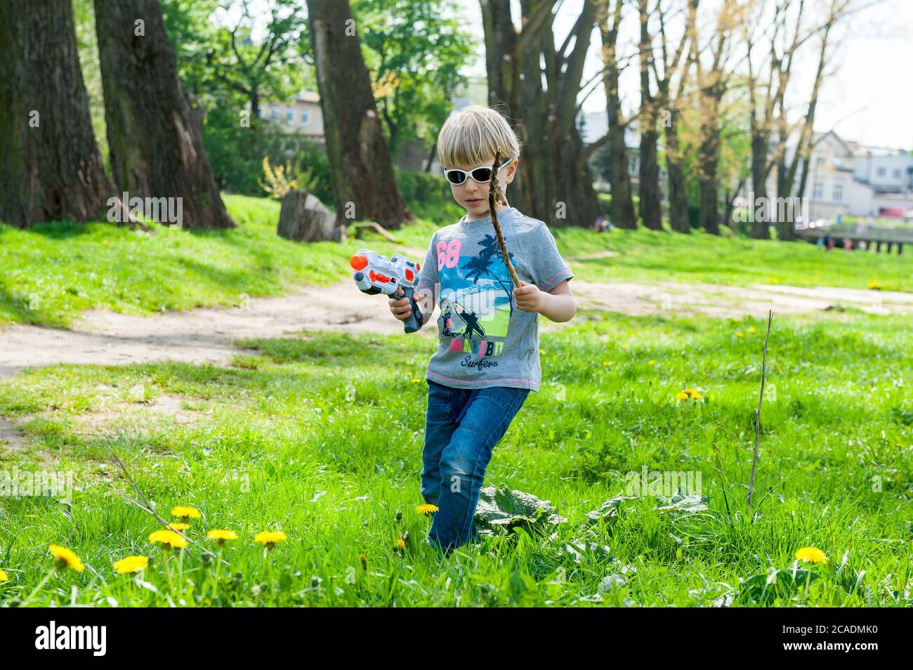 4 year old boy playing with a stick and toy gun Stock Photo - Alamy