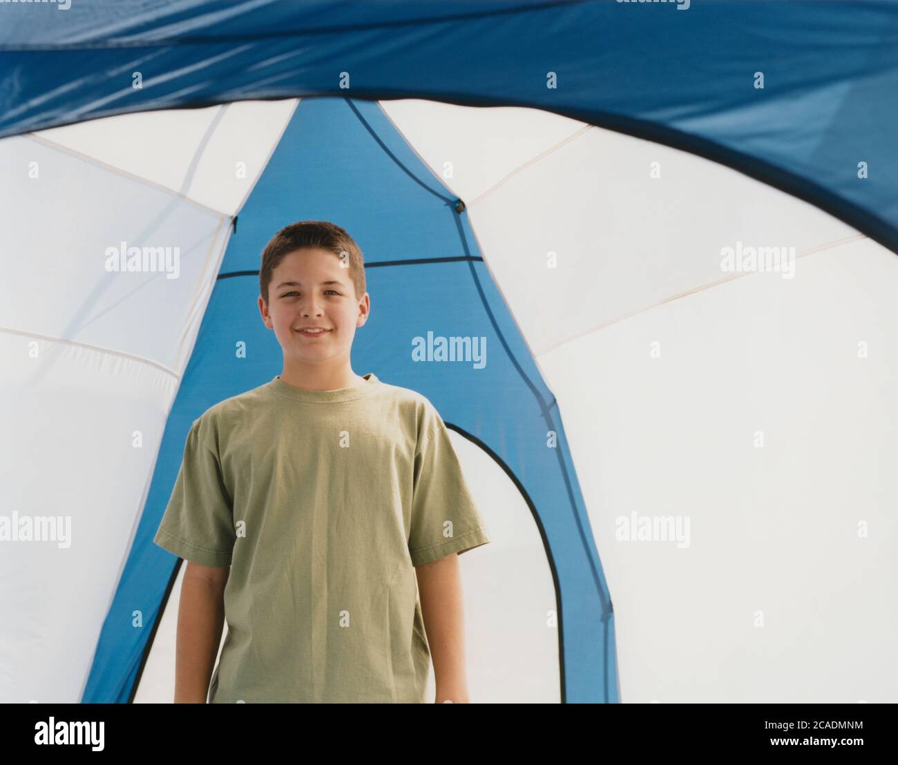 Happy adolescent boy standing upright in a dome camping tent Stock ...