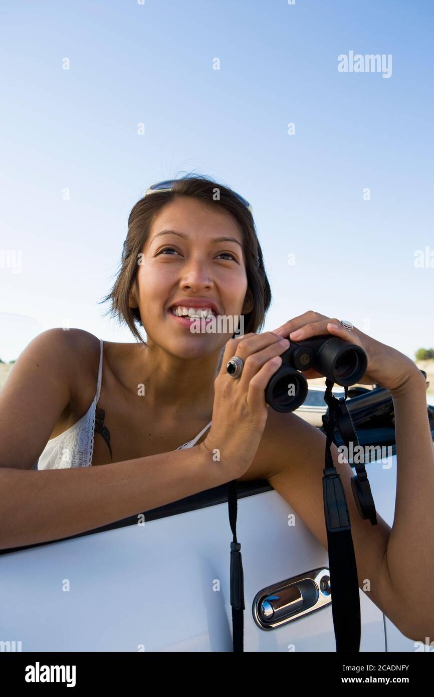 Native American woman in sun dress driving a white convertible sports ...