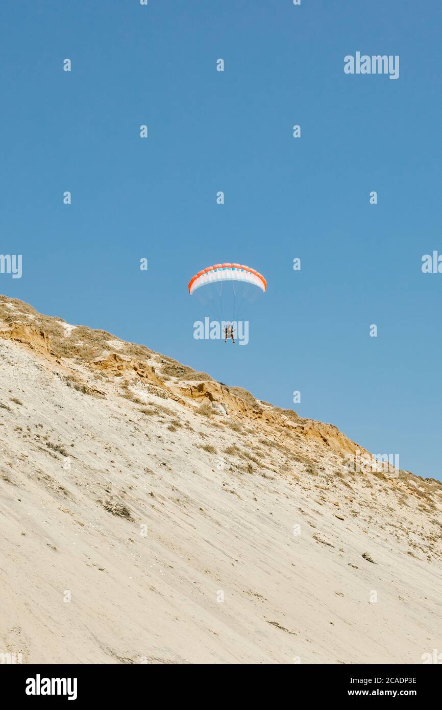 Young man paragliding during sunset off cliffs in Baja, Mexico Stock ...