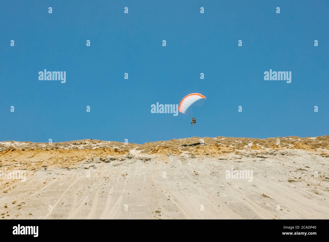 Young man paragliding during summer off cliffs in Baja, Mexico Stock ...