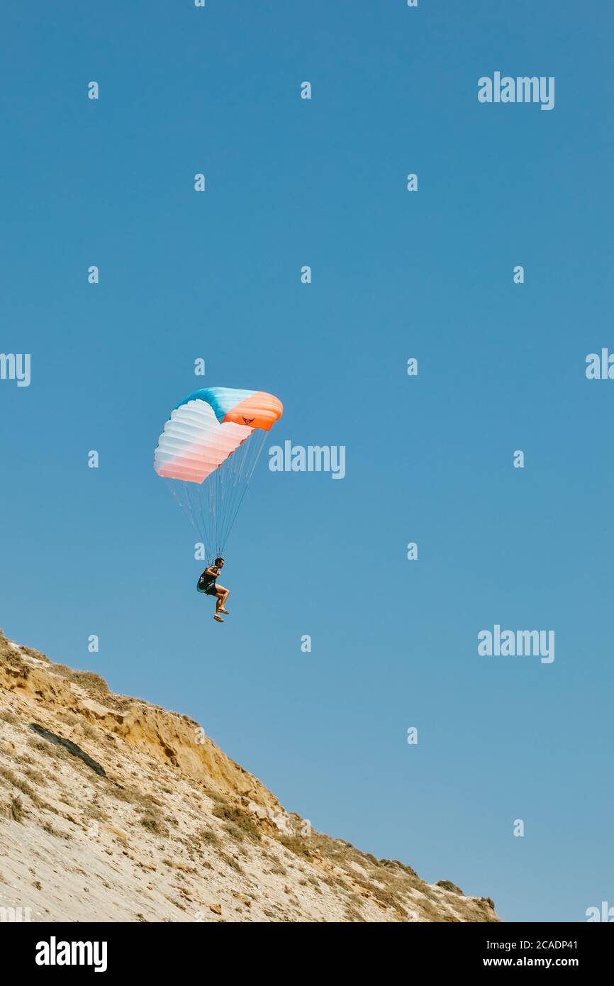 Young man paragliding during summer off cliffs in Baja, Mexico Stock ...