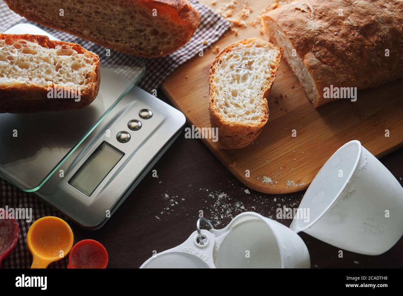 Sliced bread with the scale and measuring cups on wooden table Stock ...