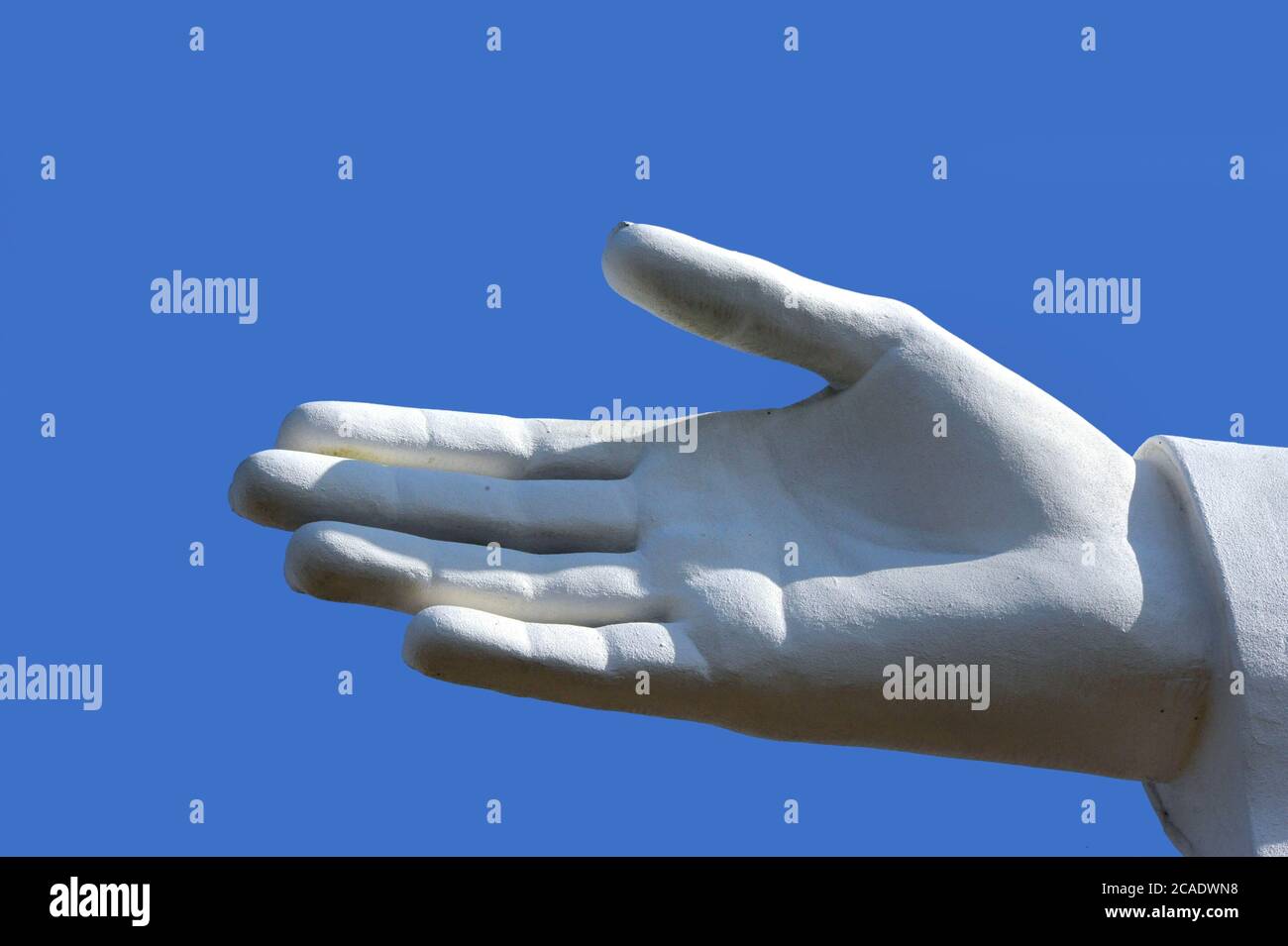 Statue has open hand as if reaching to help someone. Sky is vivid blue ...