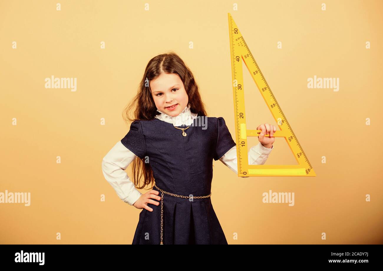 Girl with big ruler. School student study geometry. Kid school uniform ...
