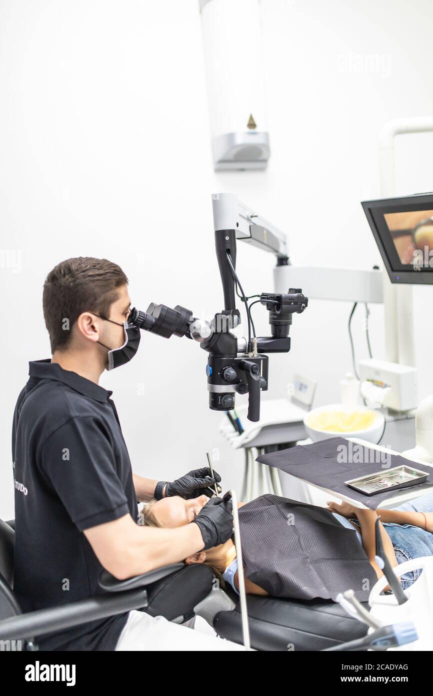 The dentist examines the patient's teeth with a dental microscope Stock ...