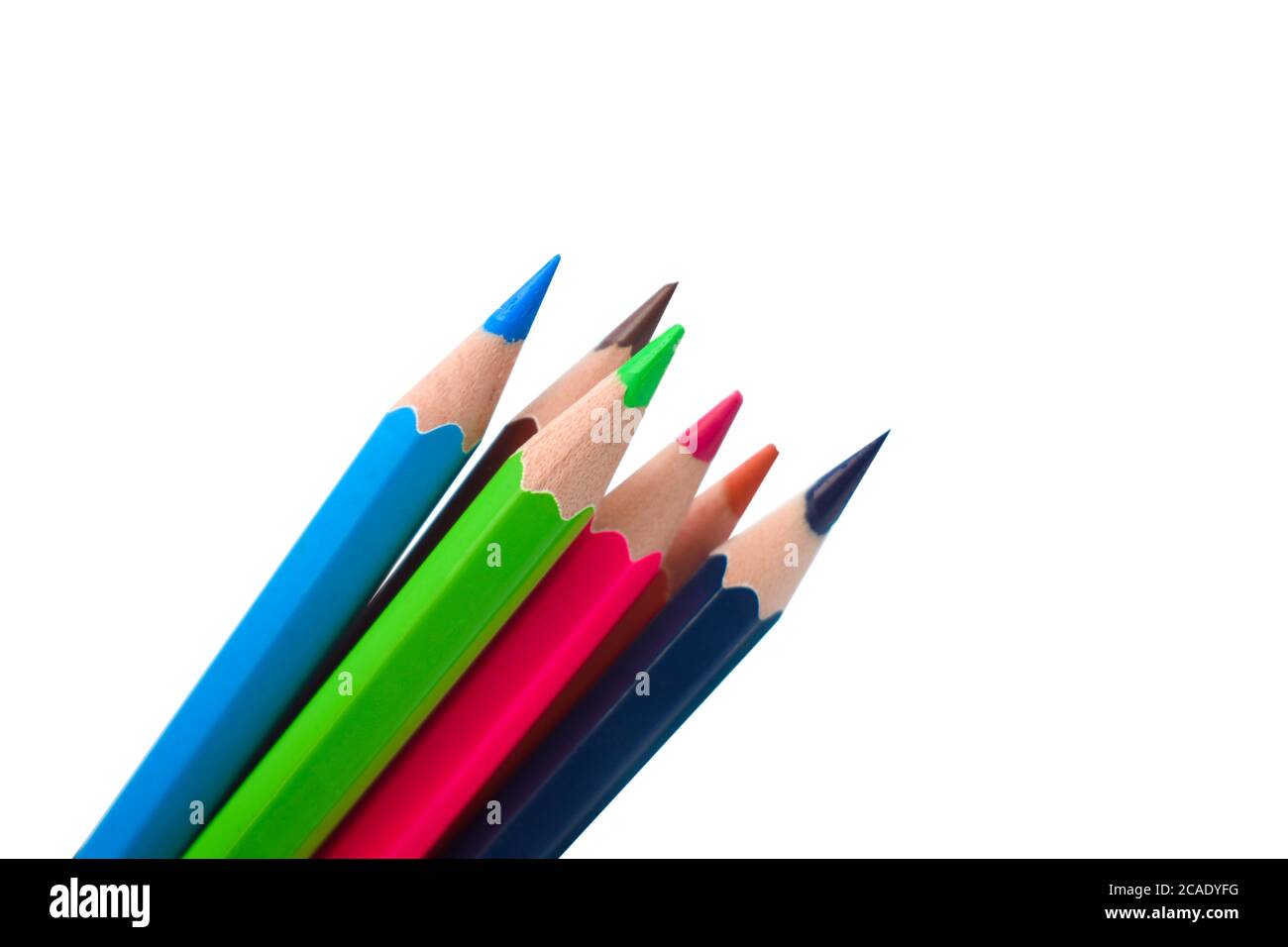 Six different colored wood pencil crayons gathered together on a white ...