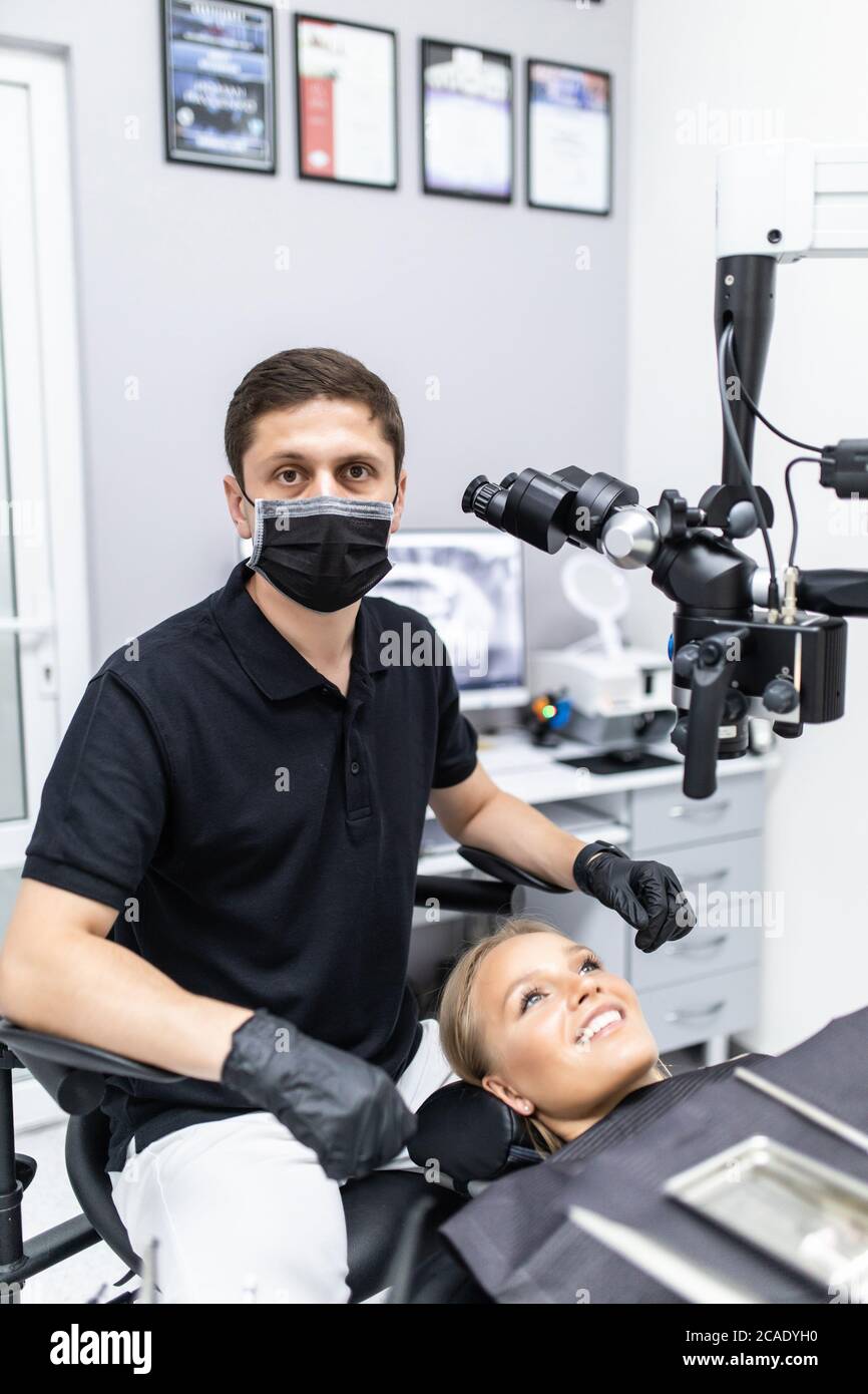 We improve your smile. Male dentist look at the patient using ...