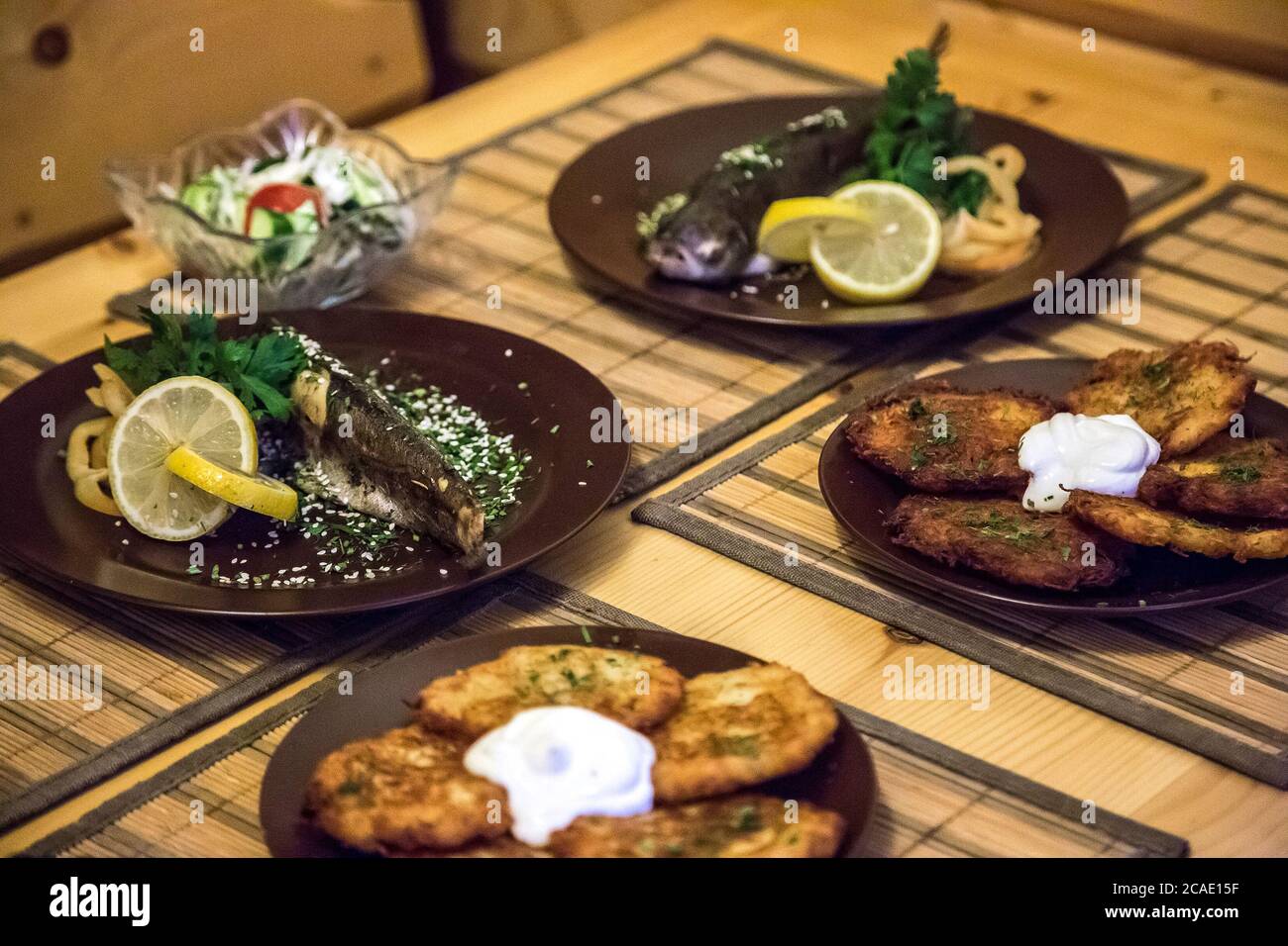 Fried fish with lemon, potato pancake in traditional dish of Hutsuls ...
