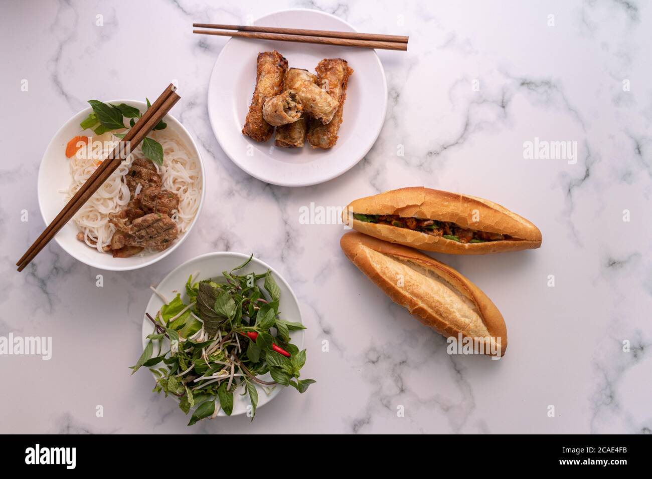 High angle shot of different Asian dishes with chopsticks on a marble ...