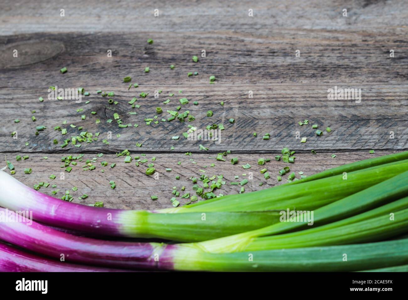 Closeup shot of fresh spring onions on a wooden surface Stock Photo - Alamy