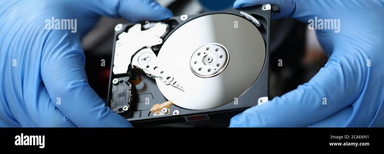 Gloved hands holding computer hard drive device Stock Photo - Alamy