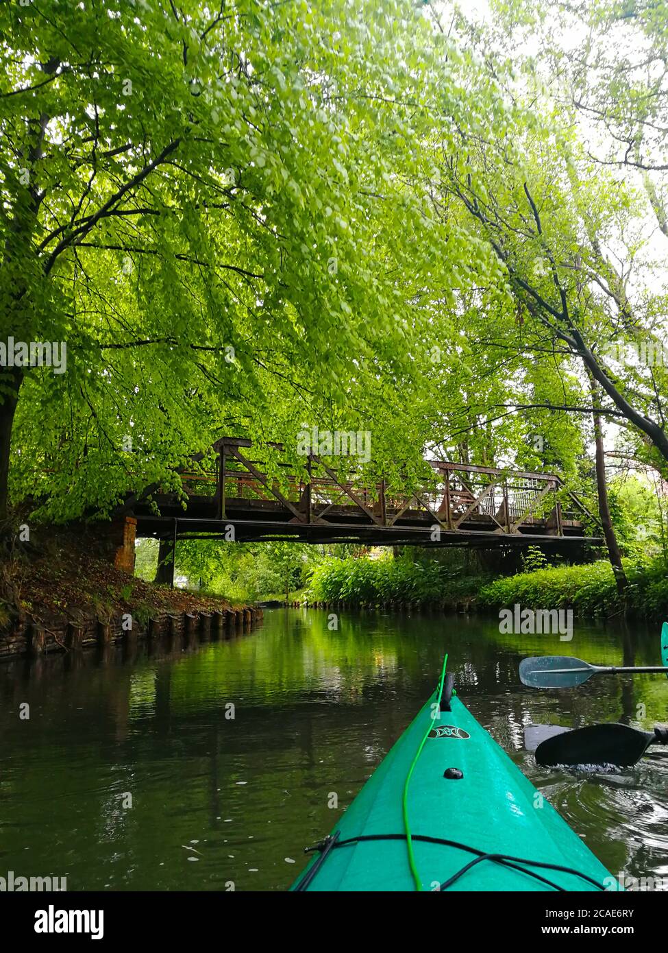 Vertical shot of a bridge over a river and a boat floating on the water ...