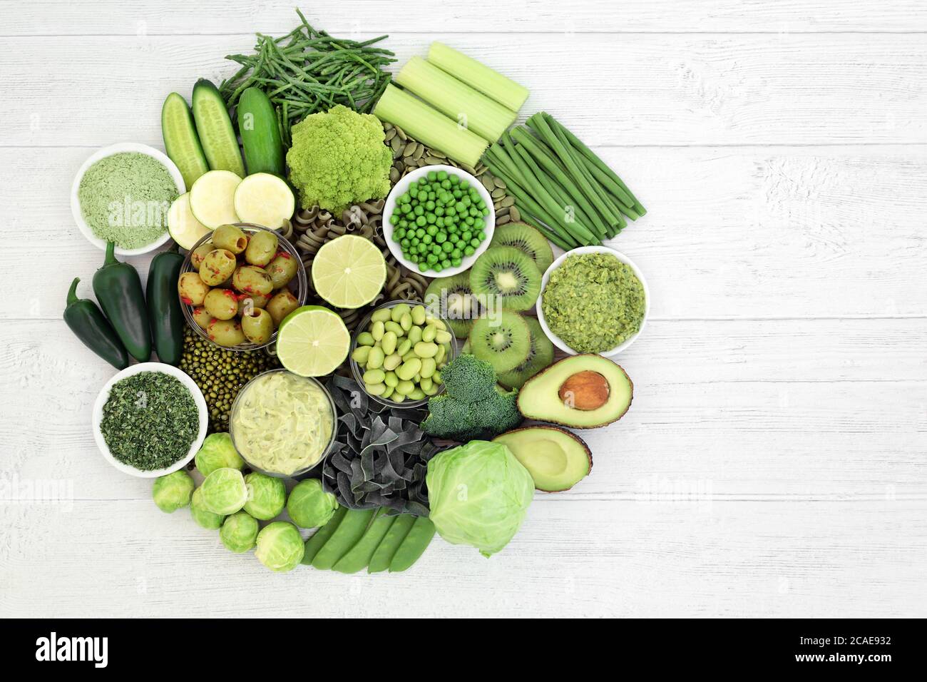 Vegan health food with plant based green vegetables and fruit on rustic ...
